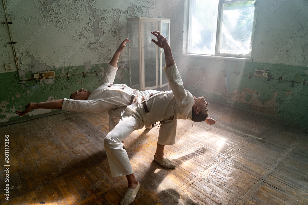 Male duo making acrobatic tricks wearing costume of insane people in ...