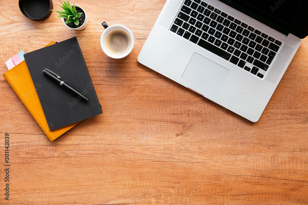 Top view of office table. Wood office desk table with laptop, cup of ...