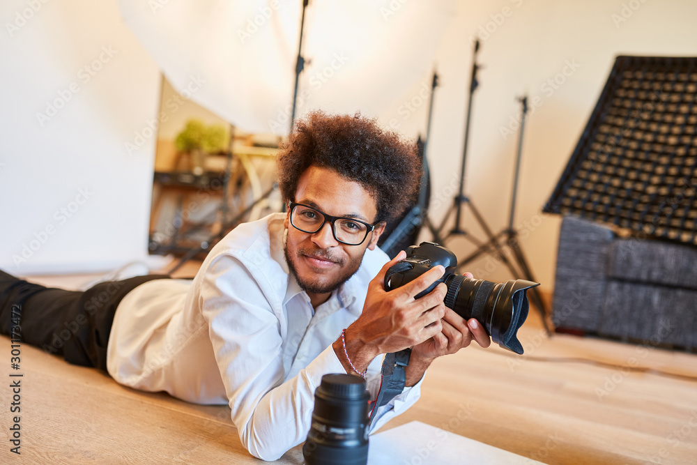 Young man as a photo student with digital camera Stock Photo | Adobe Stock