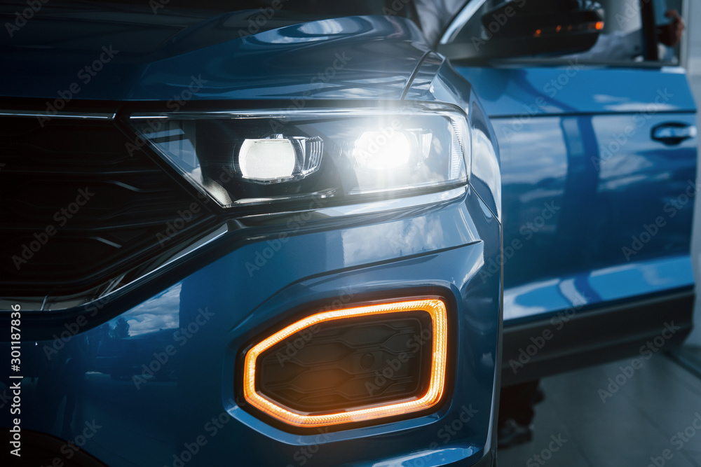 Front part of brand new modern blue car. Parked at showroom. Reflection ...