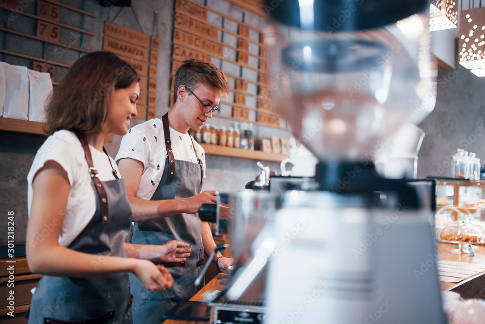 Working together. Two young cafe employees indoors. Conception of ...