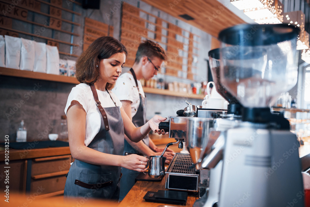 Working together. Two young cafe employees indoors. Conception of ...