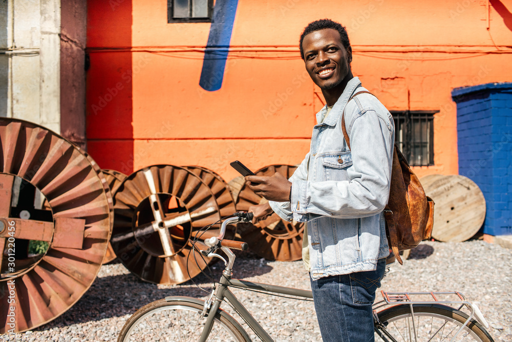 Relaxed young man commuting in the city with hos bicycle, using ...