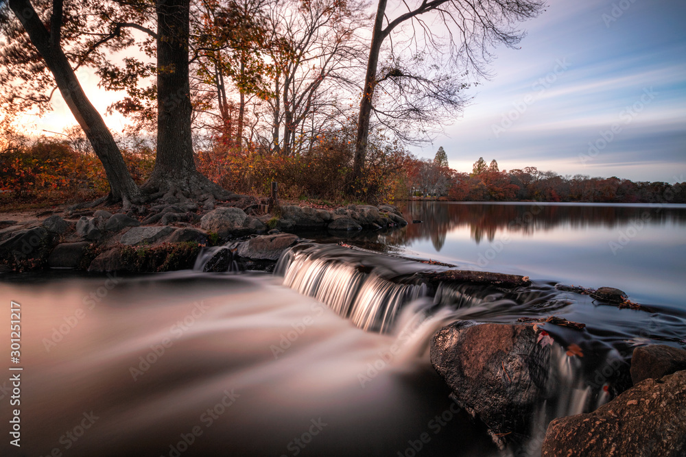 Smooth milky stream of water cascading down rocks from a glassy still ...