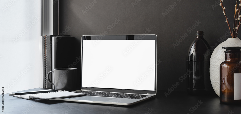 Modern office room with blank screen laptop computer and office ...