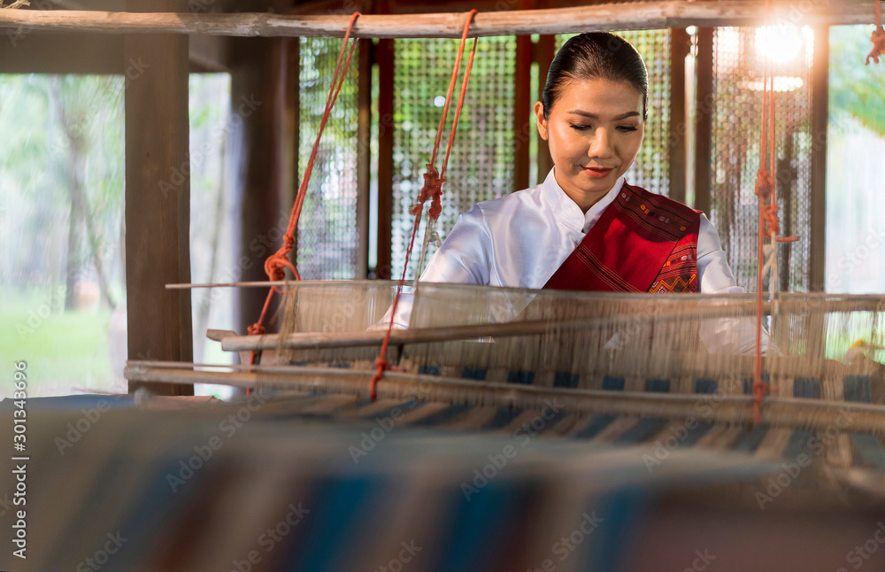 Asian female weaving silk sari on loom.young woman works on cotton or ...