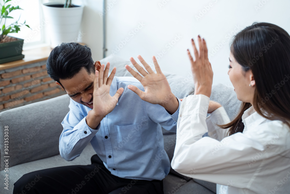 Young Asian couple having bad argument fighting on sofa at home. Wife ...