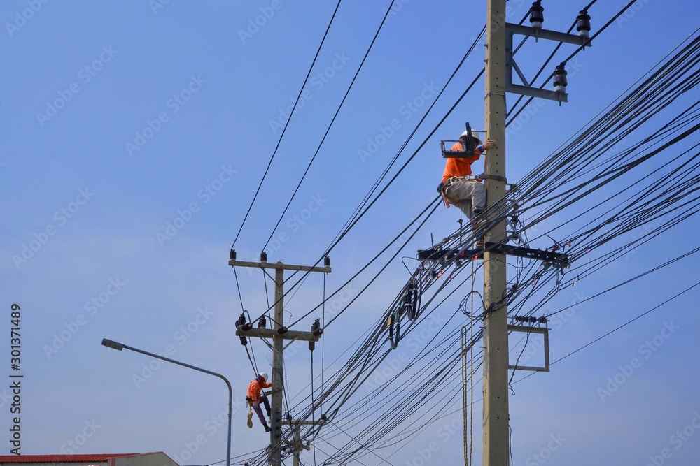 Low angle and diagonal view of electricians lineman working to install ...
