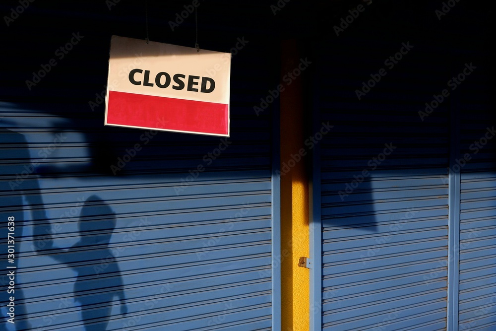Hanging closed sign board with sunlight and shadow of mother holding ...