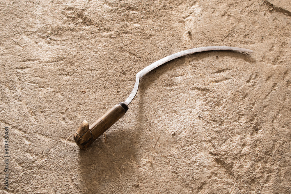 Old reaper sickle on rustic background Stock Photo | Adobe Stock