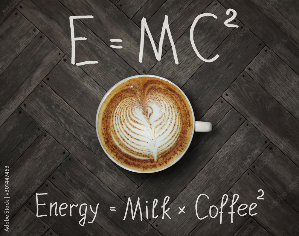 The cup of black energy coffee with milk and two funny formulas. Wooden ...