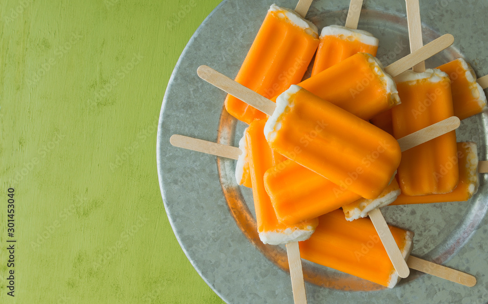Overhead view of a bunch of orange dreamsicle pops on a serving tray ...