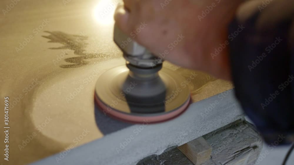 Male worker's hand uses electric craft polisher to professionally ...