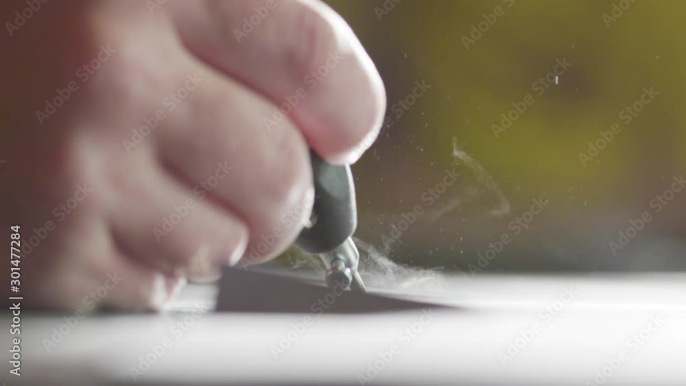 Worker's hand carefully making sandblasting writing as kind of ...