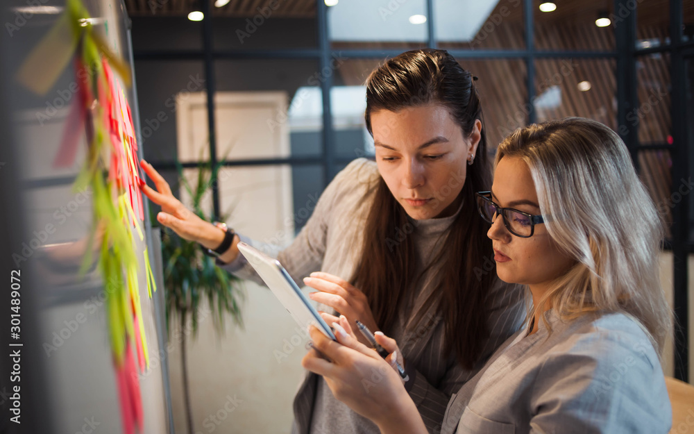 Teamwork, project management, agile methodology. Two young business ...