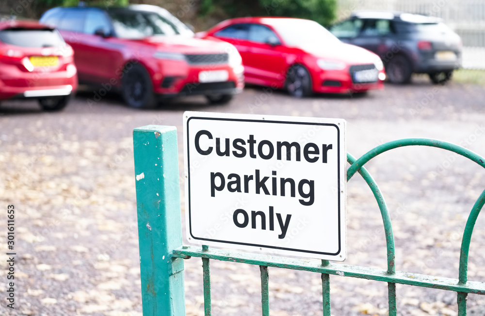 Customer parking only sign on car park staff gate at place of work ...