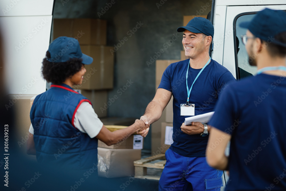 Happy delivery man greeting with his female coworker by the van. Stock ...