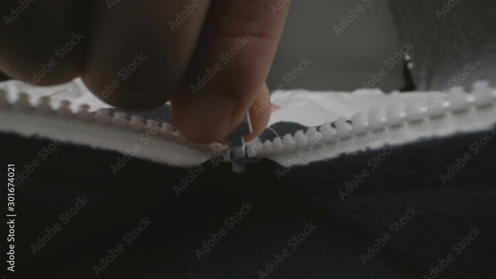 Extreme close up zipper with hand unzipping the sweater jacket zipper ...