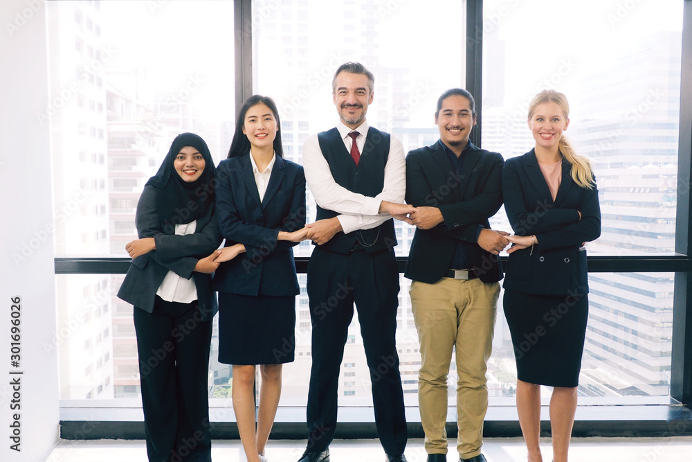 Group of diverse professional business people standing holding each ...