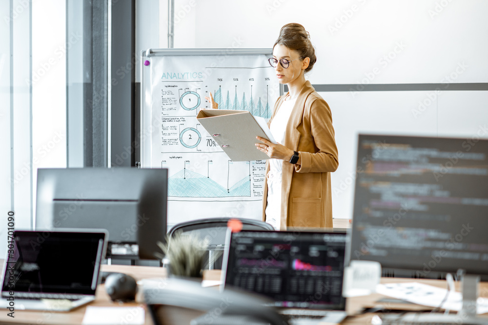 Young business woman preparing for a presentation, standing alone with ...