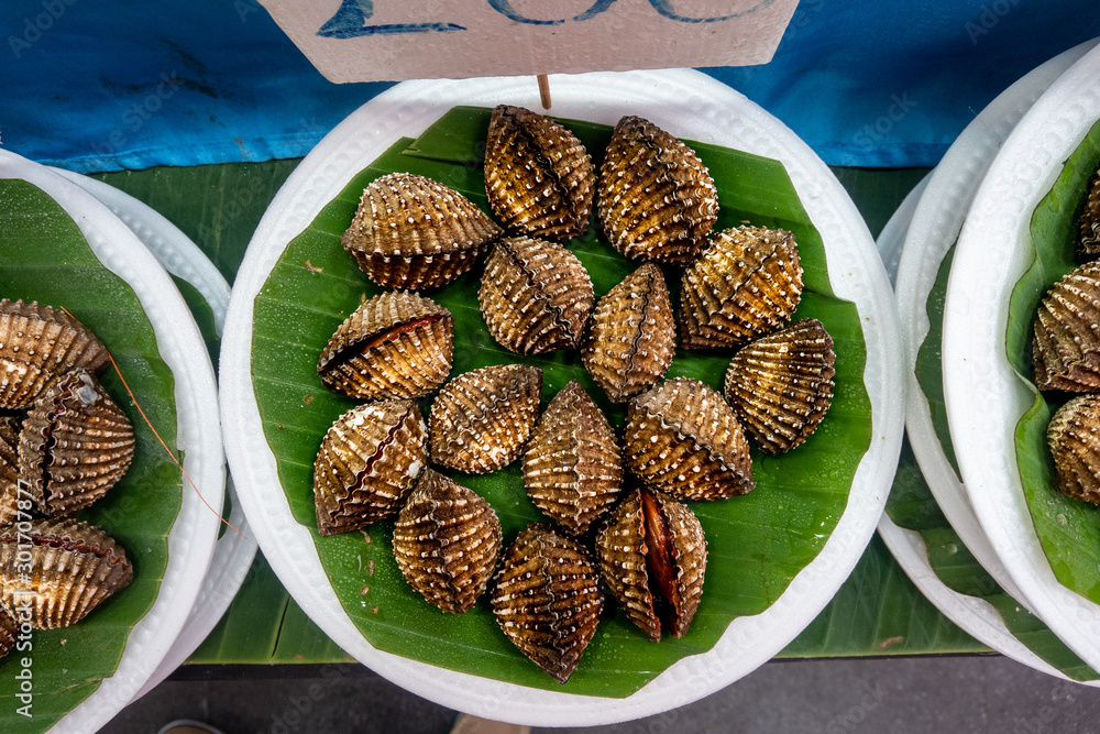 blood cockle on banana leaf in white paper plate in the market Stock ...