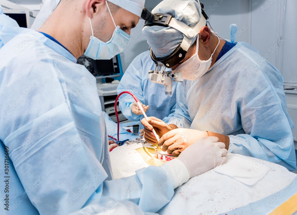 Spinal surgery. Group of surgeons in operating room with surgery ...