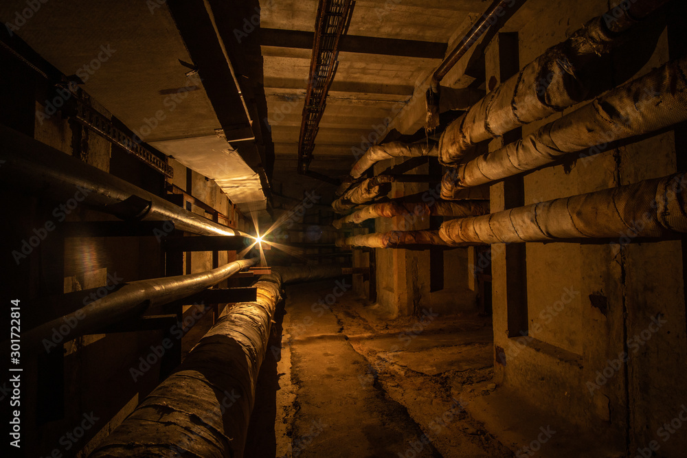 Underground concrete utility tunnel with pipes and wires. This tunnel ...