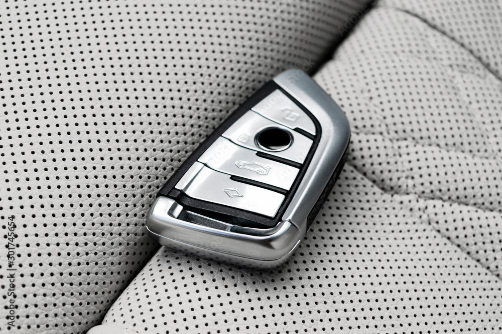 Closeup inside vehicle of wireless key ignition on white perforated ...