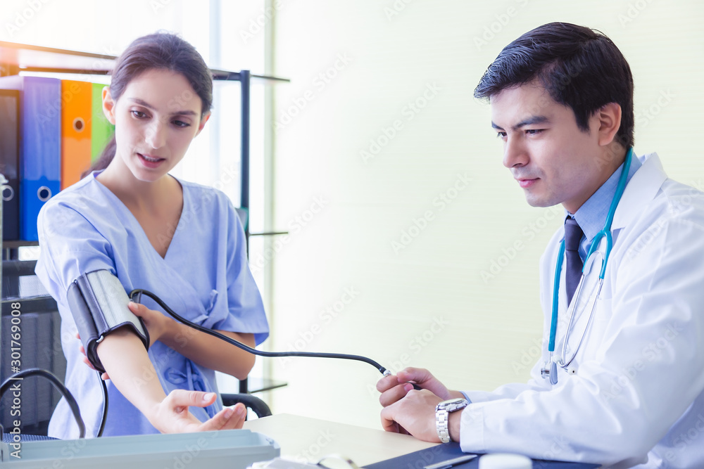 Doctor measuring blood pressure in hospital room at hospital by using ...