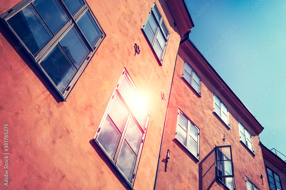 Part of the facade of a red historic building illuminated, reflecting ...