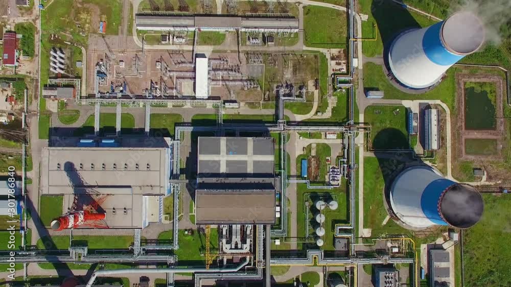Aerial view of a large power plant with pipes and steam, buildings and ...
