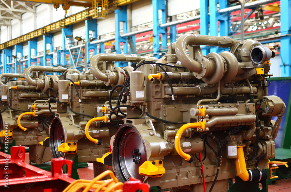 Diesel engines with huge turbines on assembly line in the workshop of ...