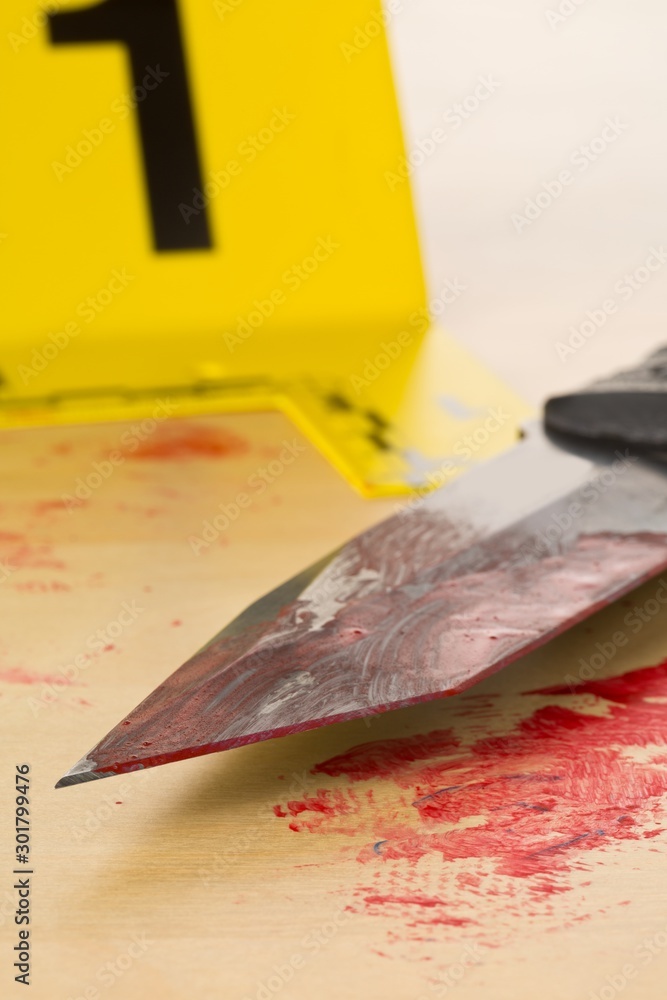 Crime scene investigation CSI evidence marker with bloody knife on wood ...