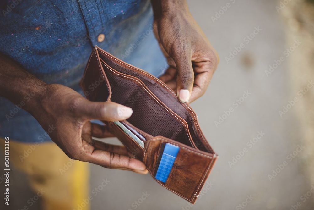 Overhead shot of a male holding his empty wallet with a blurred ...