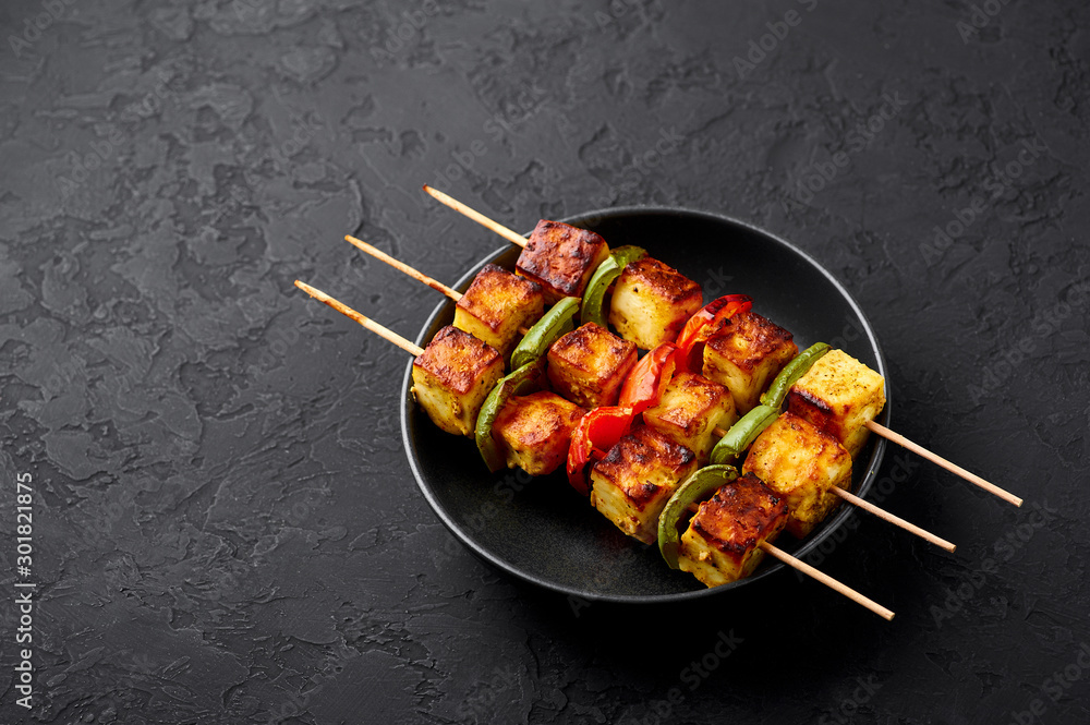 Paneer Tikka at skewers in black bowl at dark slate background. Paneer ...