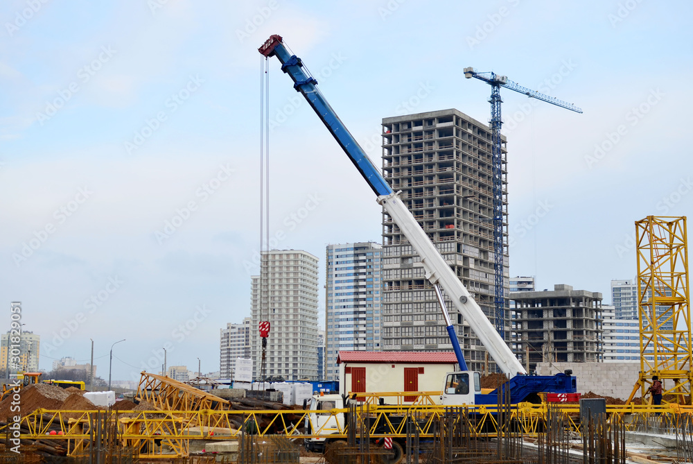 Installation of a tower crane. A truck crane lifts a load at a ...