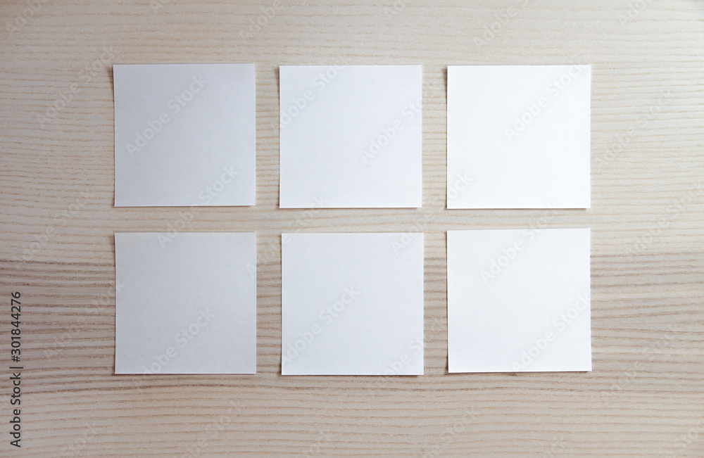 6 blank empty white sticky notes on clean wood background, from top ...
