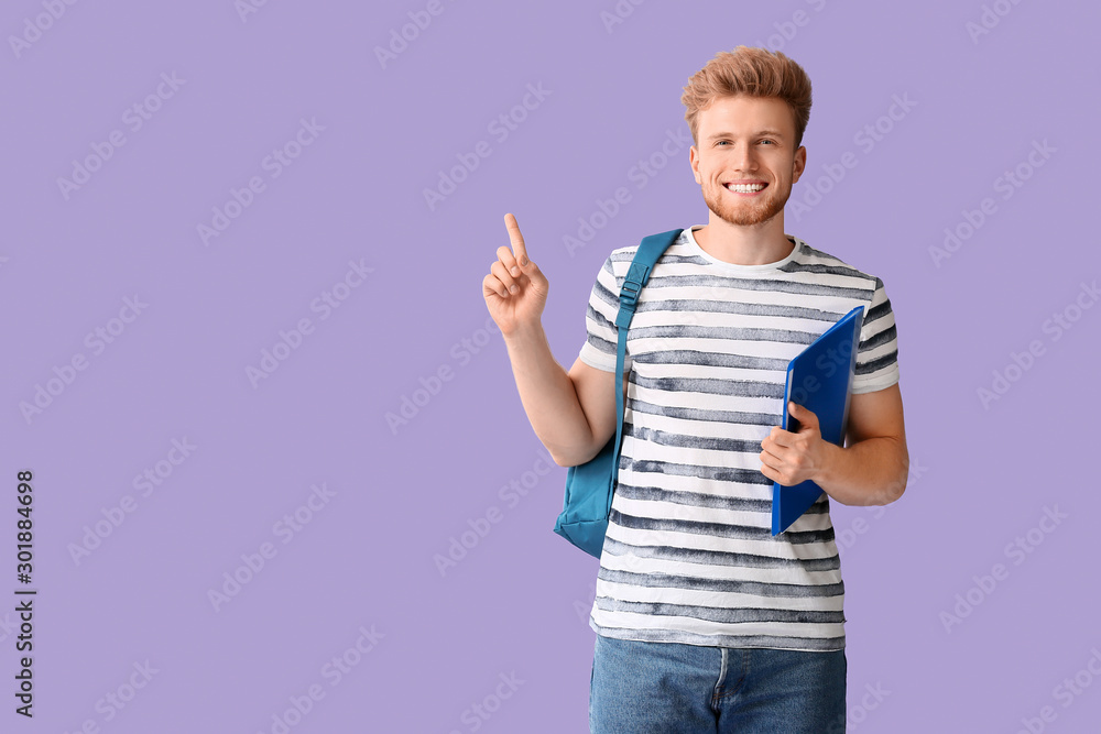 Portrait of male student showing something on color background Stock ...