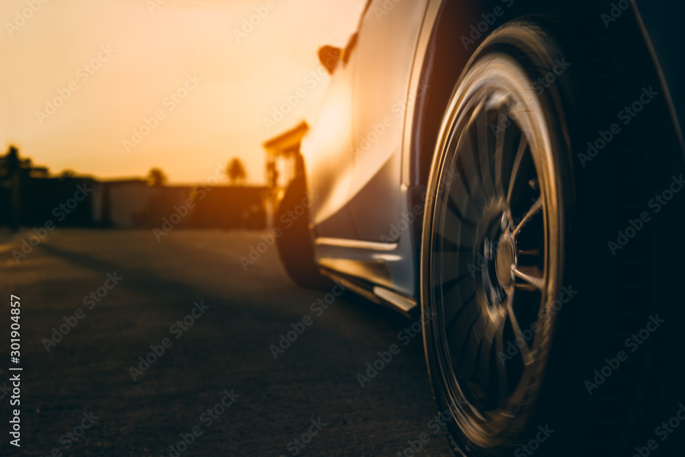 Closeup spinning alloy sports wheel car driving on the road fast speed ...
