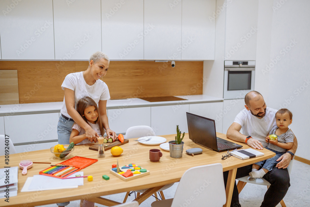 Happy family, father holding son, mother teaching daughter to cook ...