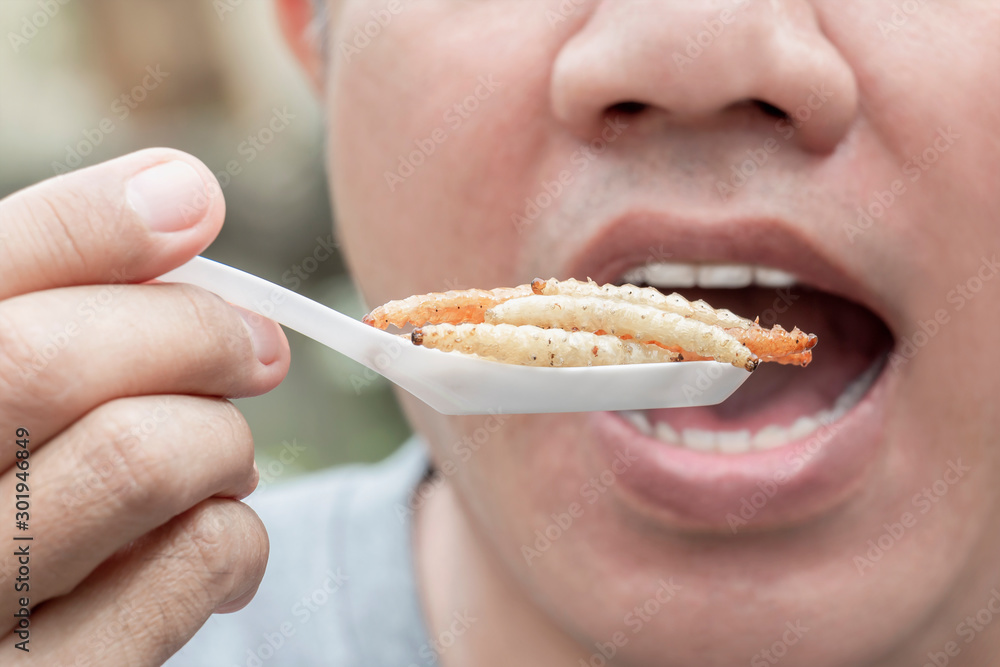 Food Insect: Man hand holding spoon eating Bamboo Worm insect or Bamboo ...