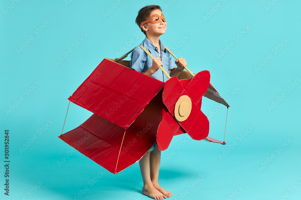 Little caucasian boy flying on red carboard airplane, happy boy in ...