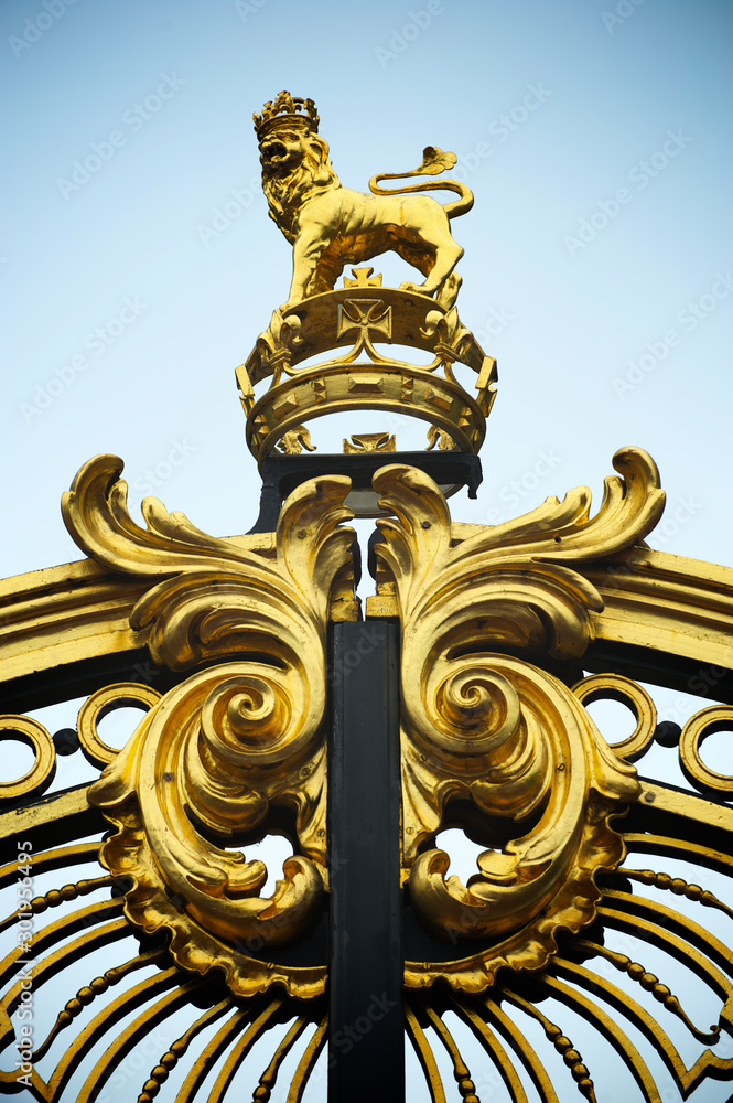 Shiny golden lion with crown standing atop a larger crown at the top of ...