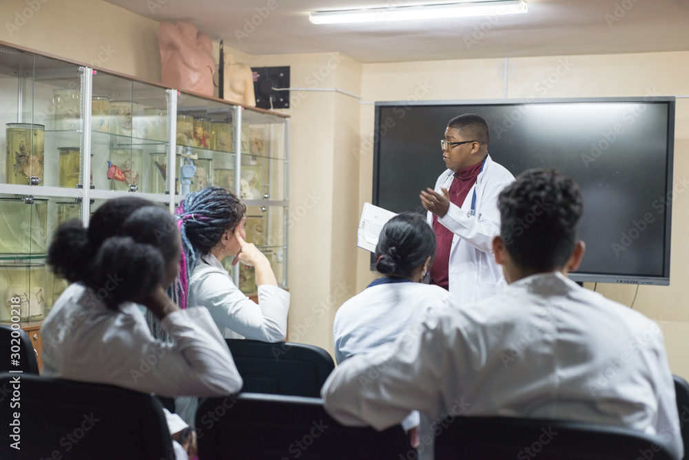 medical teacher, conducts a lesson for medical students. A group of ...