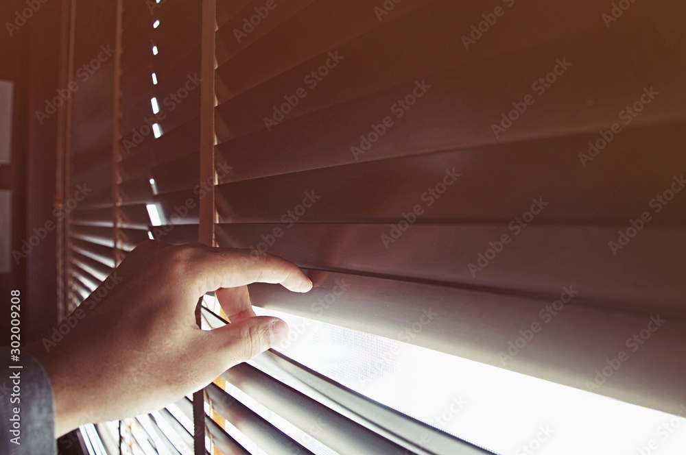 Hand's man on blinds, Looking through wooden window blinds, sun light ...