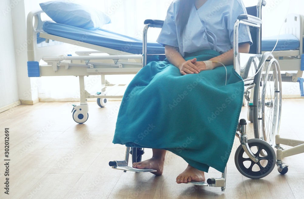 Patient sit alone on wheelchair with background sunny light in hospital ...