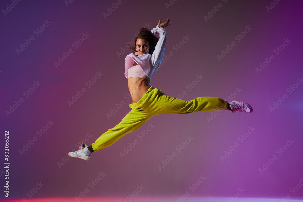 Beautiful cheerful girl jumping doing split leap in the air, looking ...