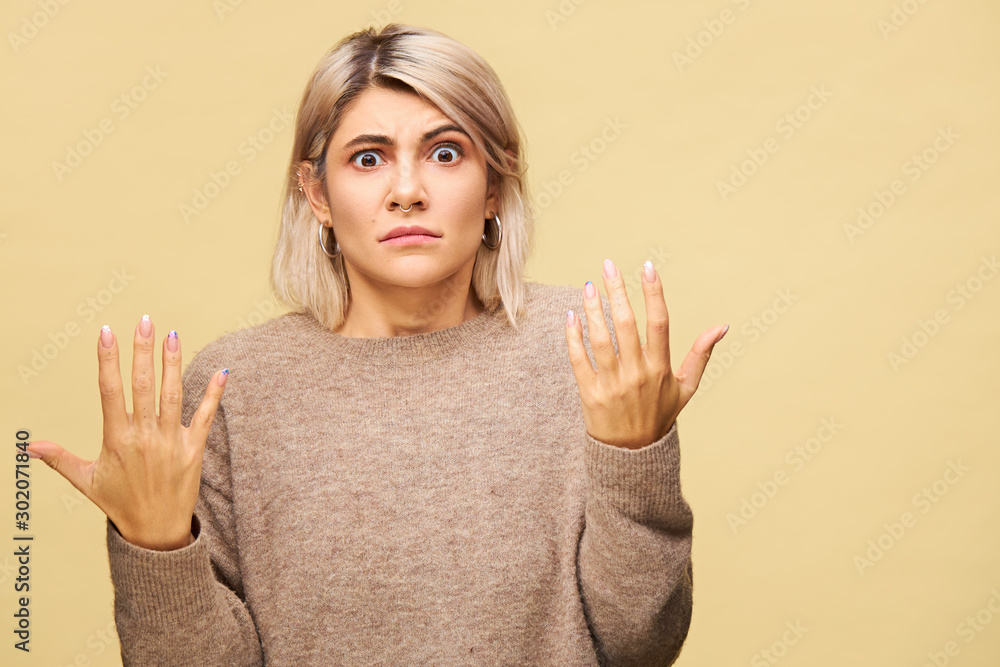 Attractive stylish young woman with blonde bob hairstyle gesturing ...