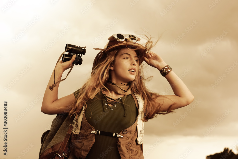 A young girl dresses up as an explorer. She wears a jungle hat and ...