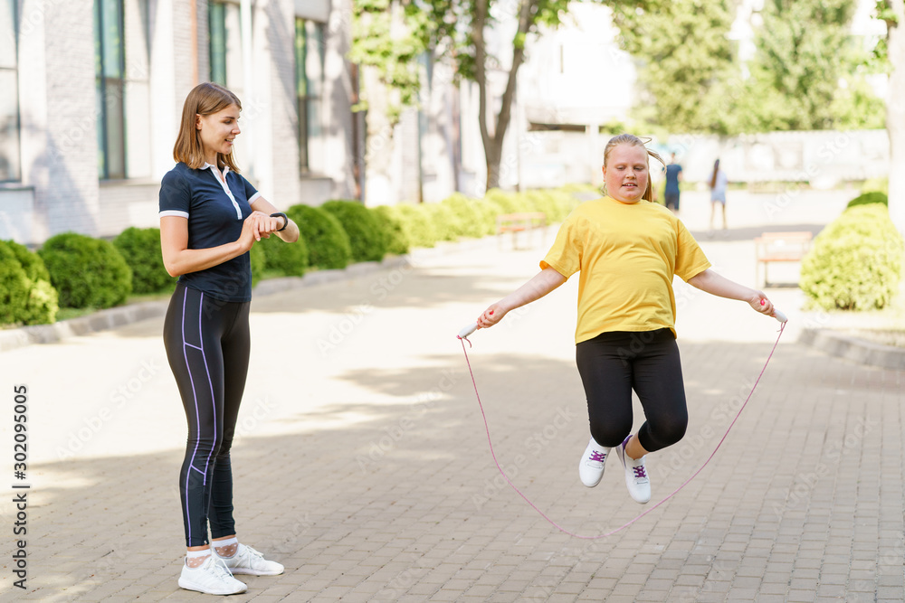 Girl jumping with a rope, doing cardio workout under her fitness ...